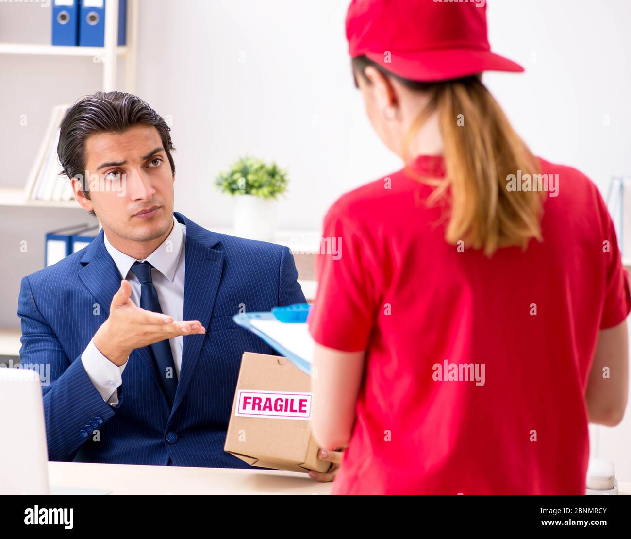 The courier delivering parcel to the office Stock Photo - Alamy