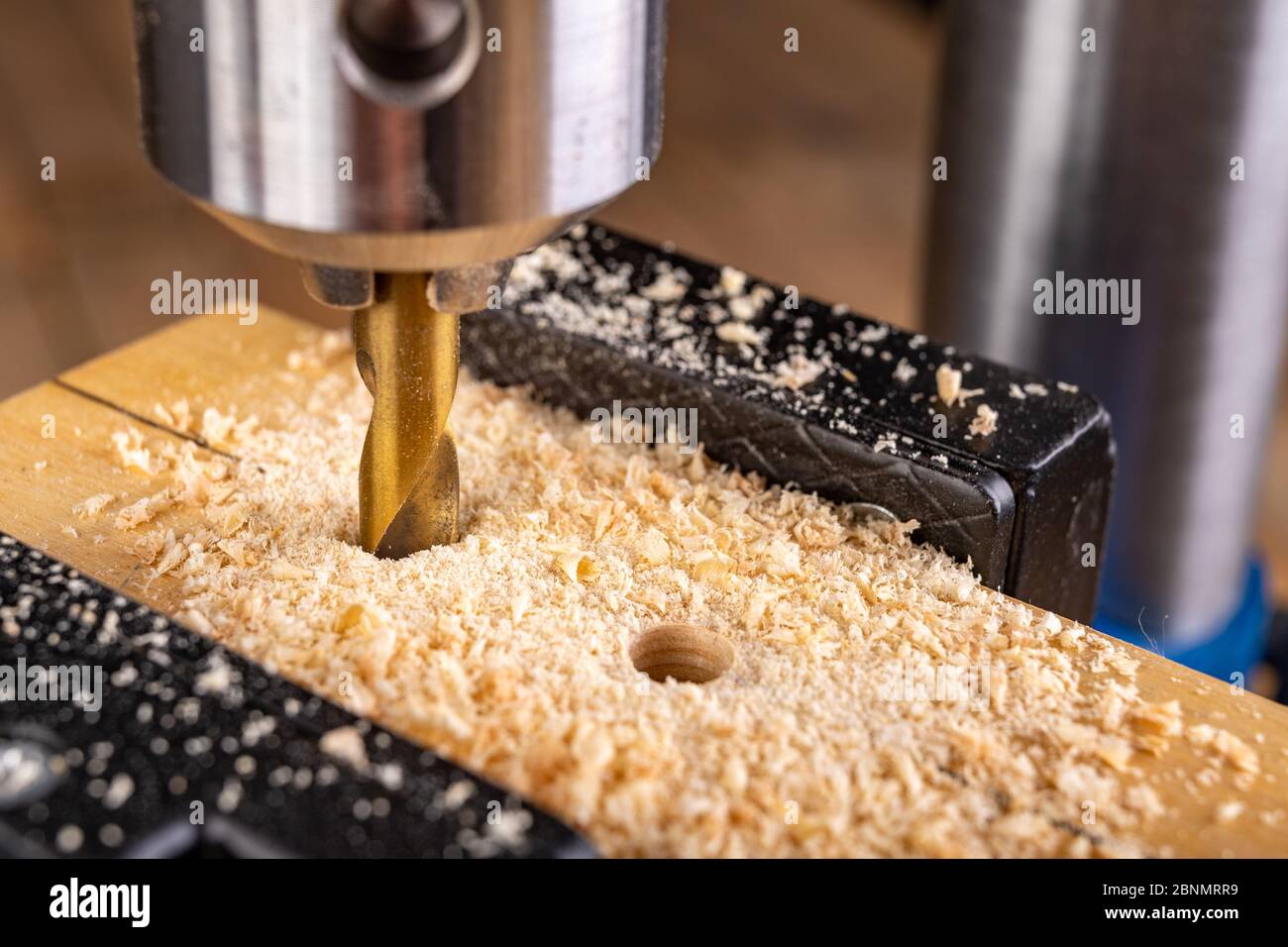 Drilling in wood with professional tools. Work on a bench drill ...