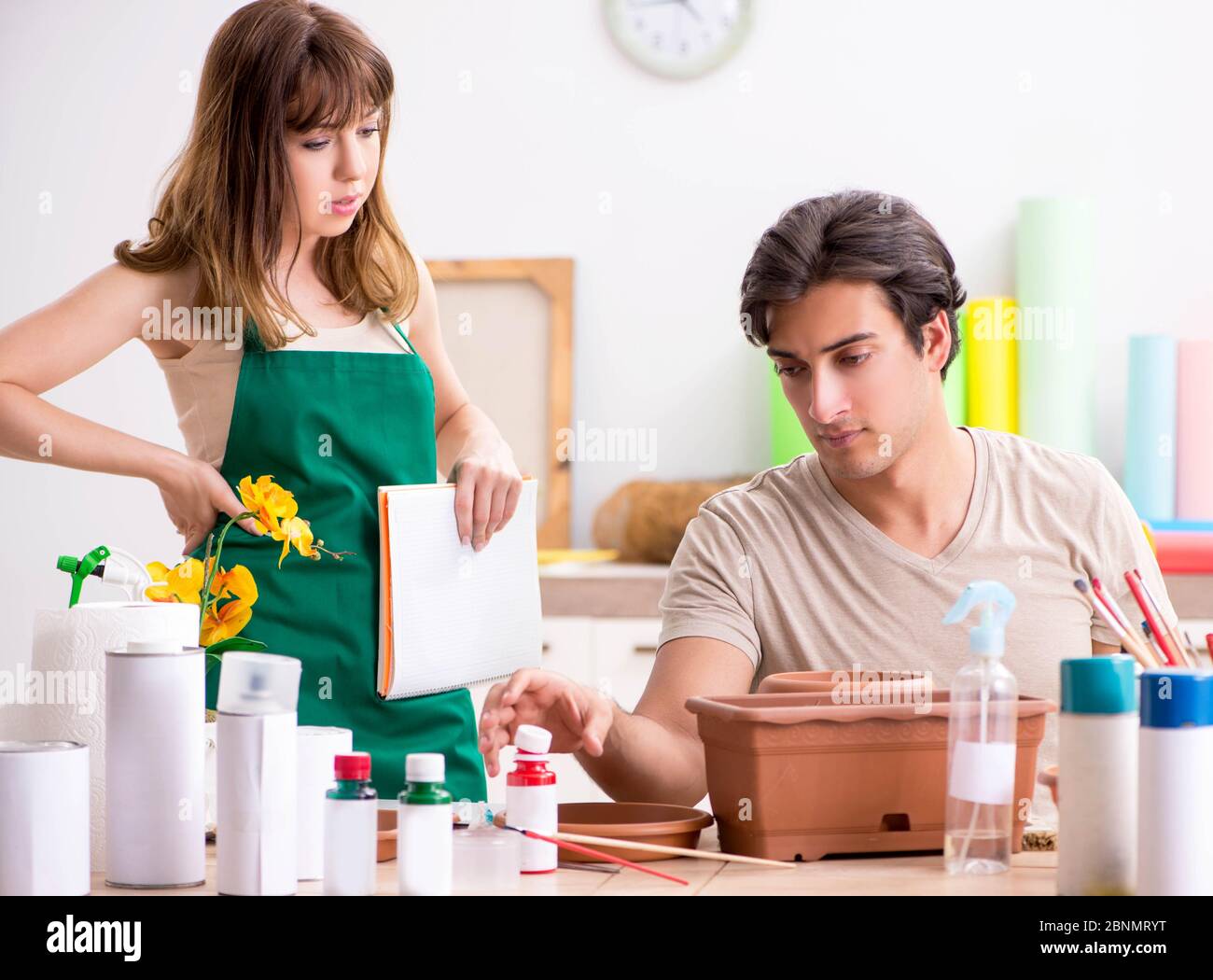 The couple decorating pots in workshop during class Stock Photo - Alamy