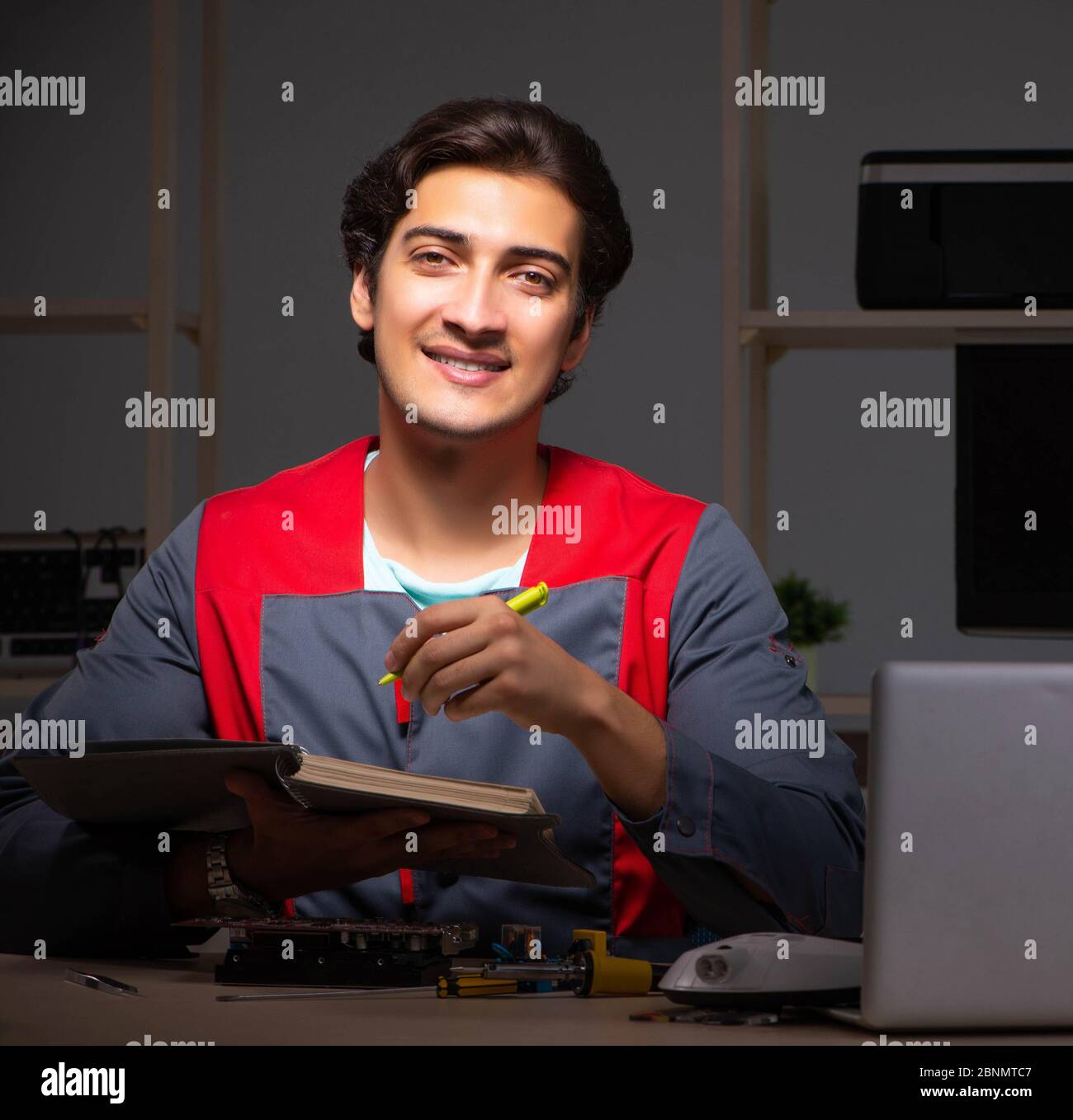 The young handsome repairman repairing computer Stock Photo - Alamy