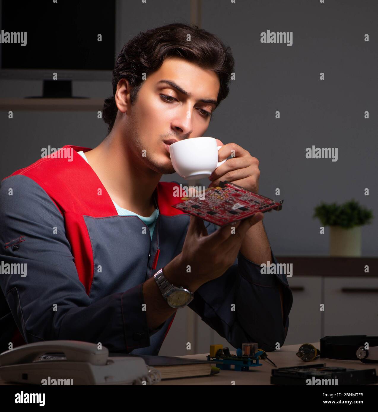 The young handsome repairman repairing computer Stock Photo - Alamy