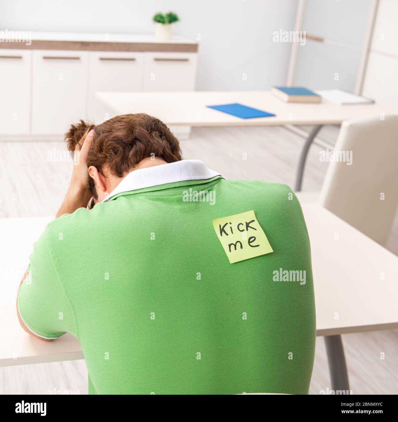 The office prank with kick me message on sticky note Stock Photo - Alamy