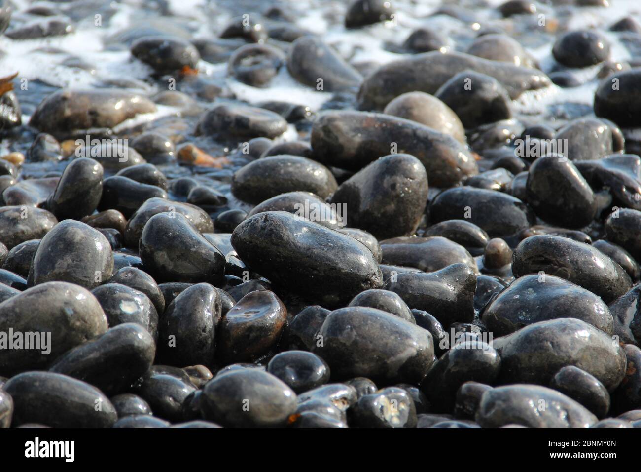 Large black rocks lie on a beach near Dover in southern England ...