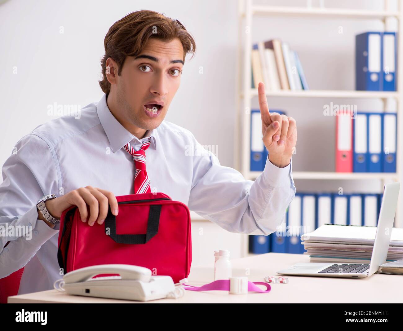 The man with first aid kit in the office Stock Photo - Alamy