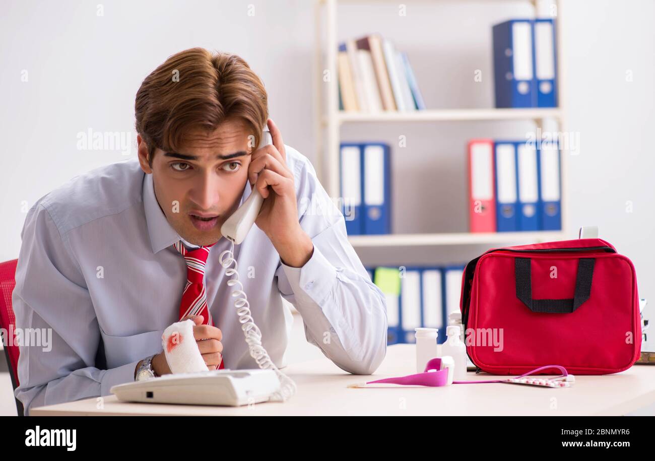 The man with first aid kit in the office Stock Photo - Alamy