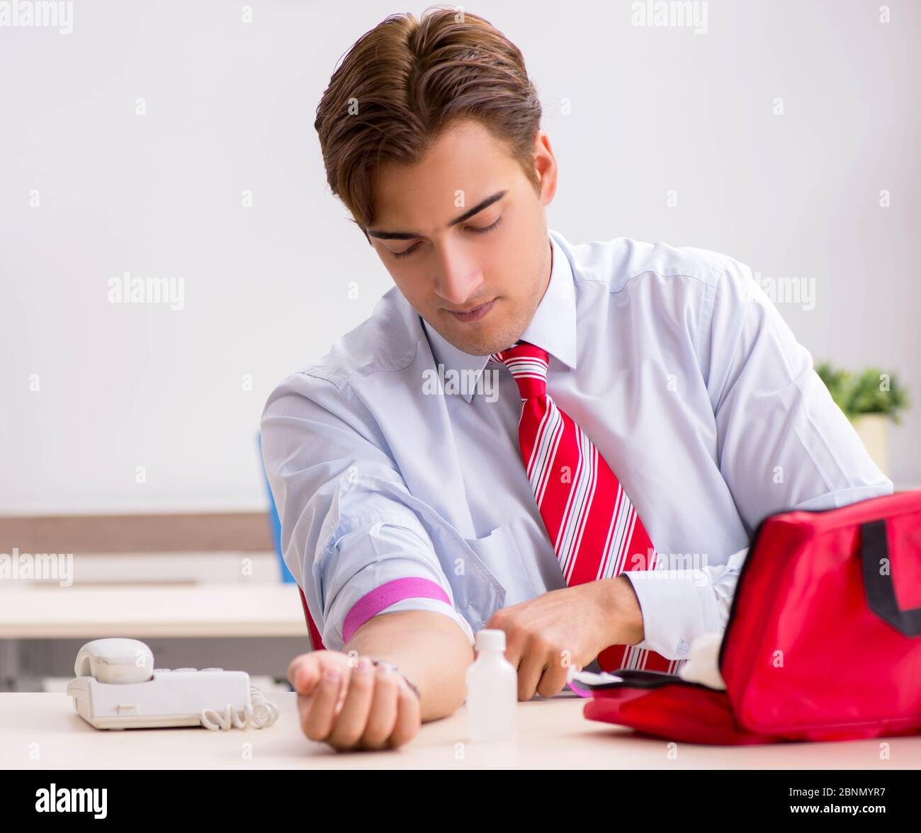The man with first aid kit in the office Stock Photo - Alamy