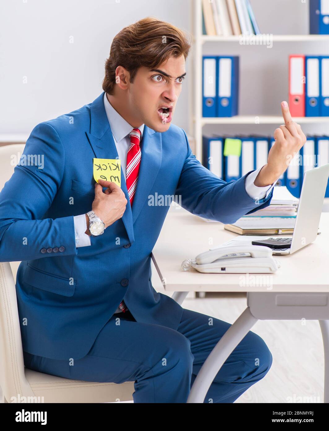 The office prank with kick me message on sticky note Stock Photo - Alamy