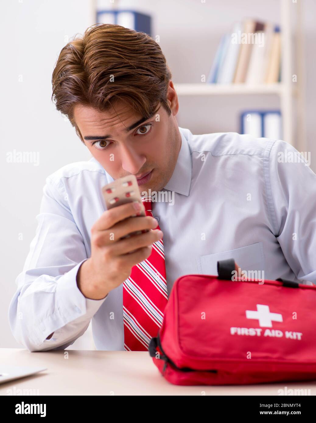 The man with first aid kit in the office Stock Photo - Alamy