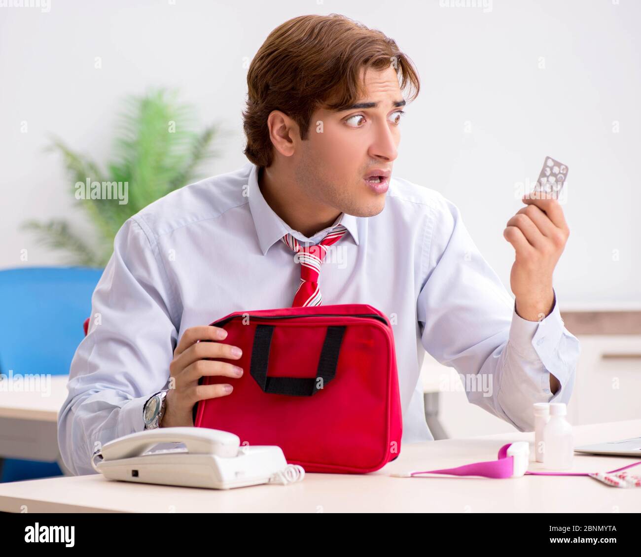 The man with first aid kit in the office Stock Photo - Alamy
