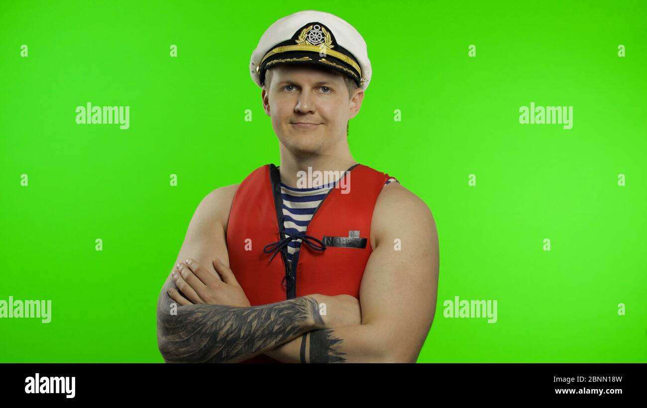 Young muscular sailor man works as lifeguard at beach arms crossed ...