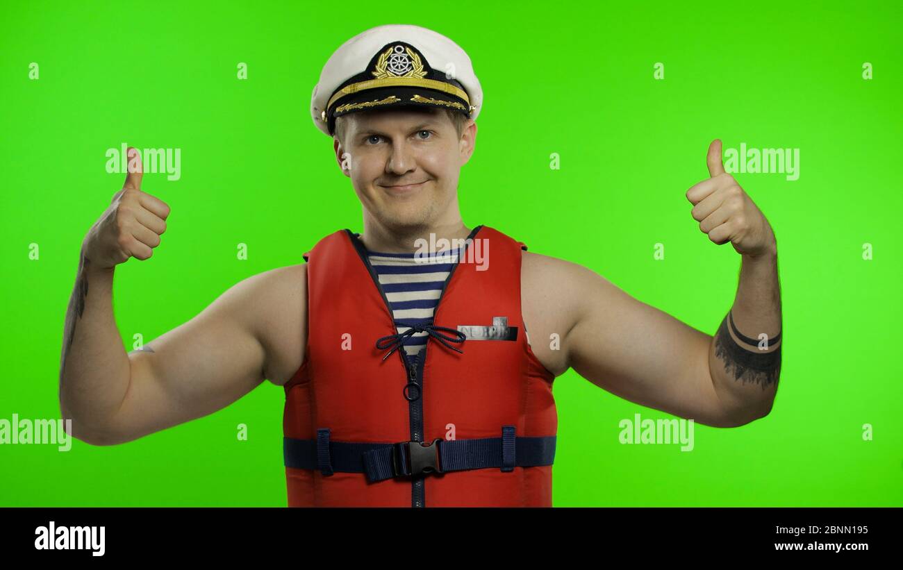 Young muscular sailor man works as lifeguard at beach show thumbs up ...