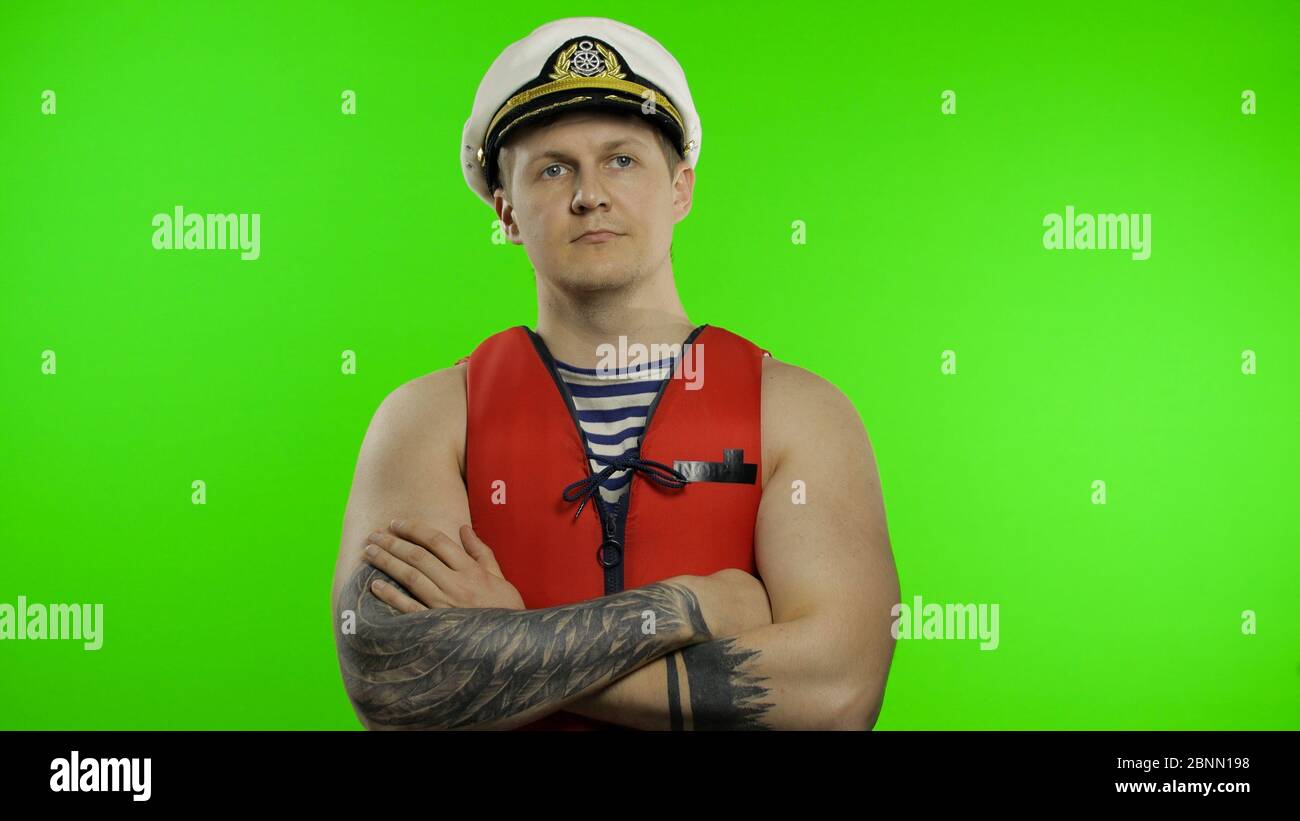 Young muscular sailor man works as lifeguard at beach observe the ...