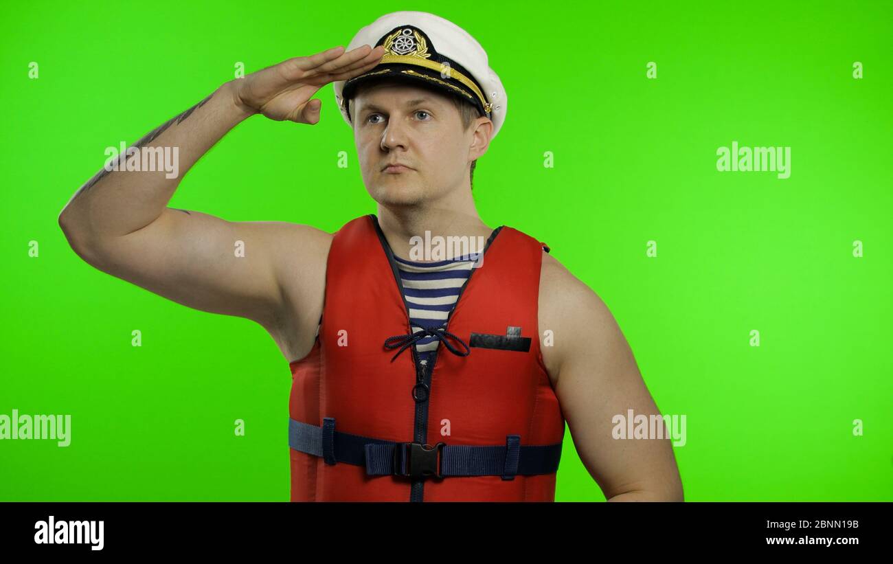 Young muscular sailor man works as lifeguard at beach observe the ...
