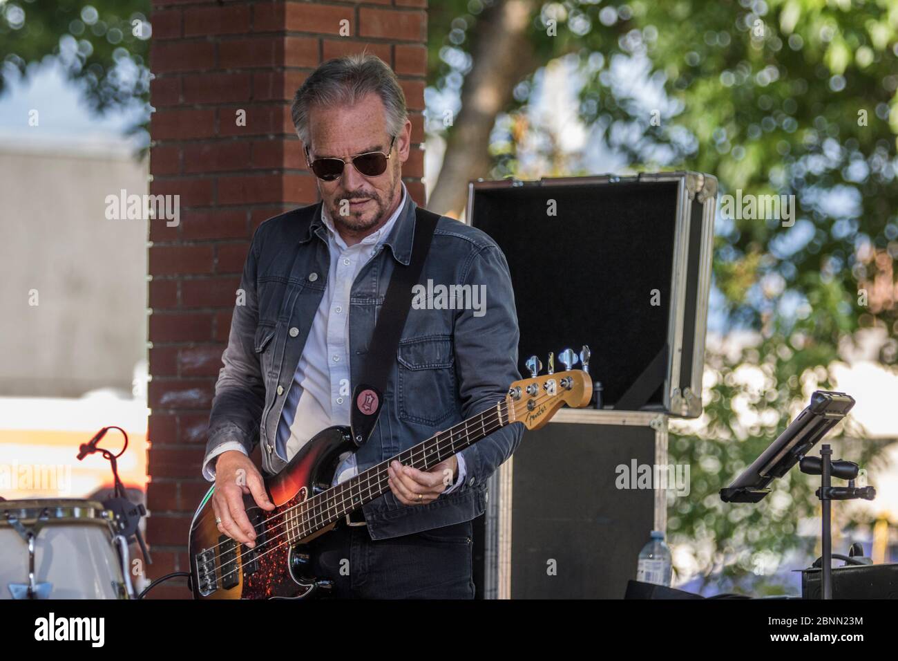 Bass player, in band, playing at outdoor concert Stock Photo - Alamy