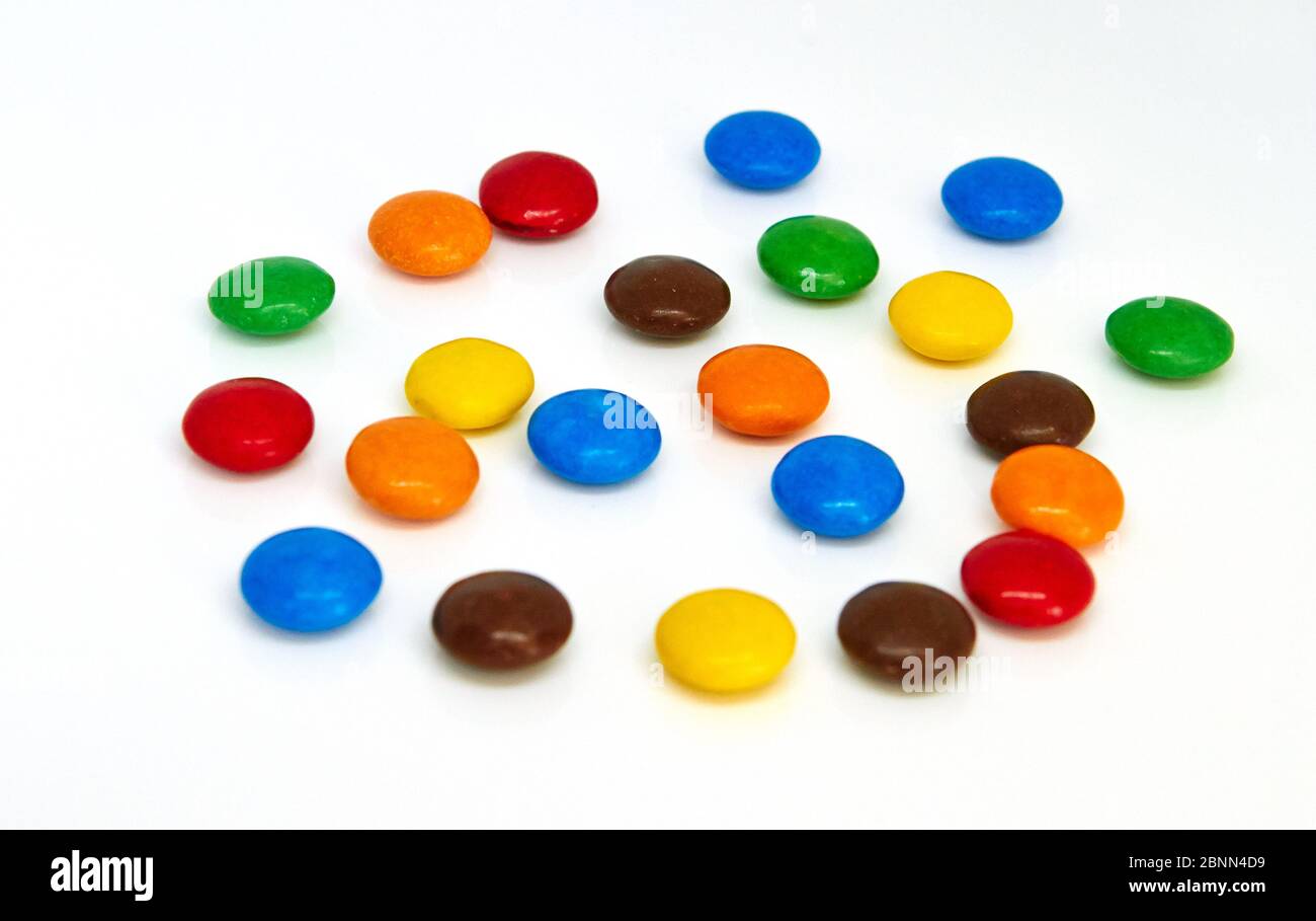 Colorful chocolate buttons on a white background Stock Photo - Alamy