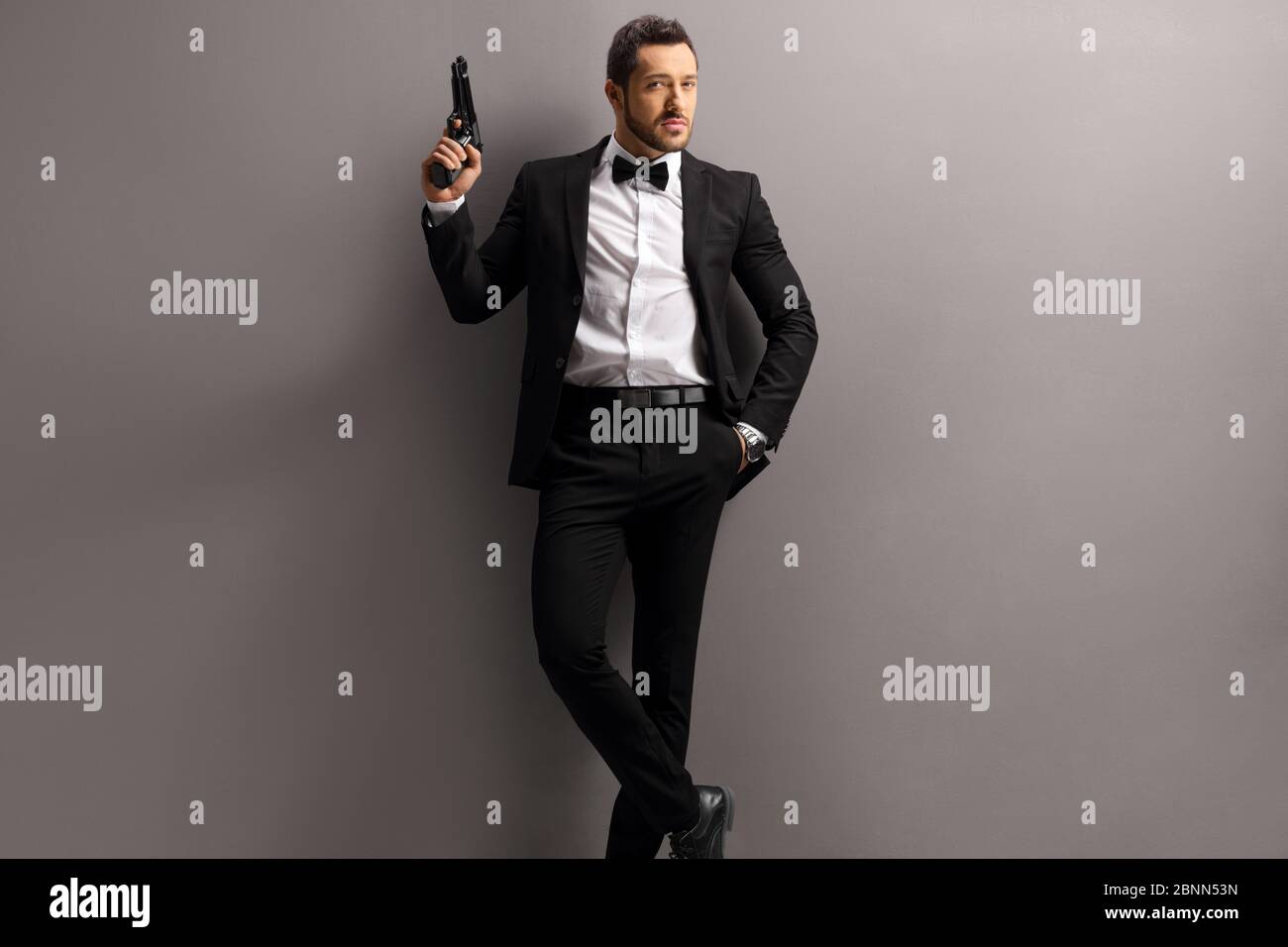 Young handsome man holding hand gun hi-res stock photography and images ...