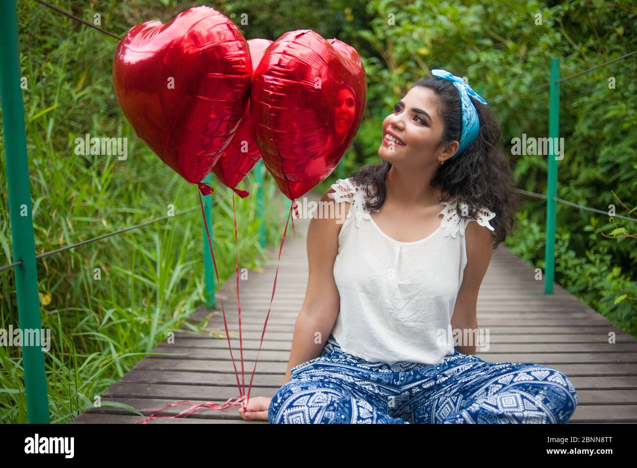 Girl holding balloons sitting on hi-res stock photography and images ...
