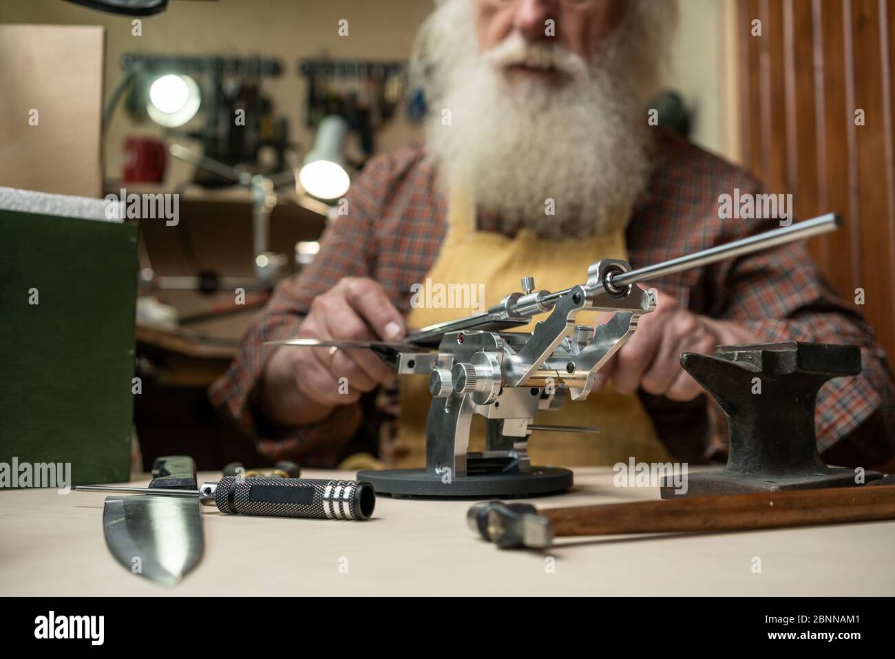 Male profession. Master knife sharpener working in the Studio Stock ...