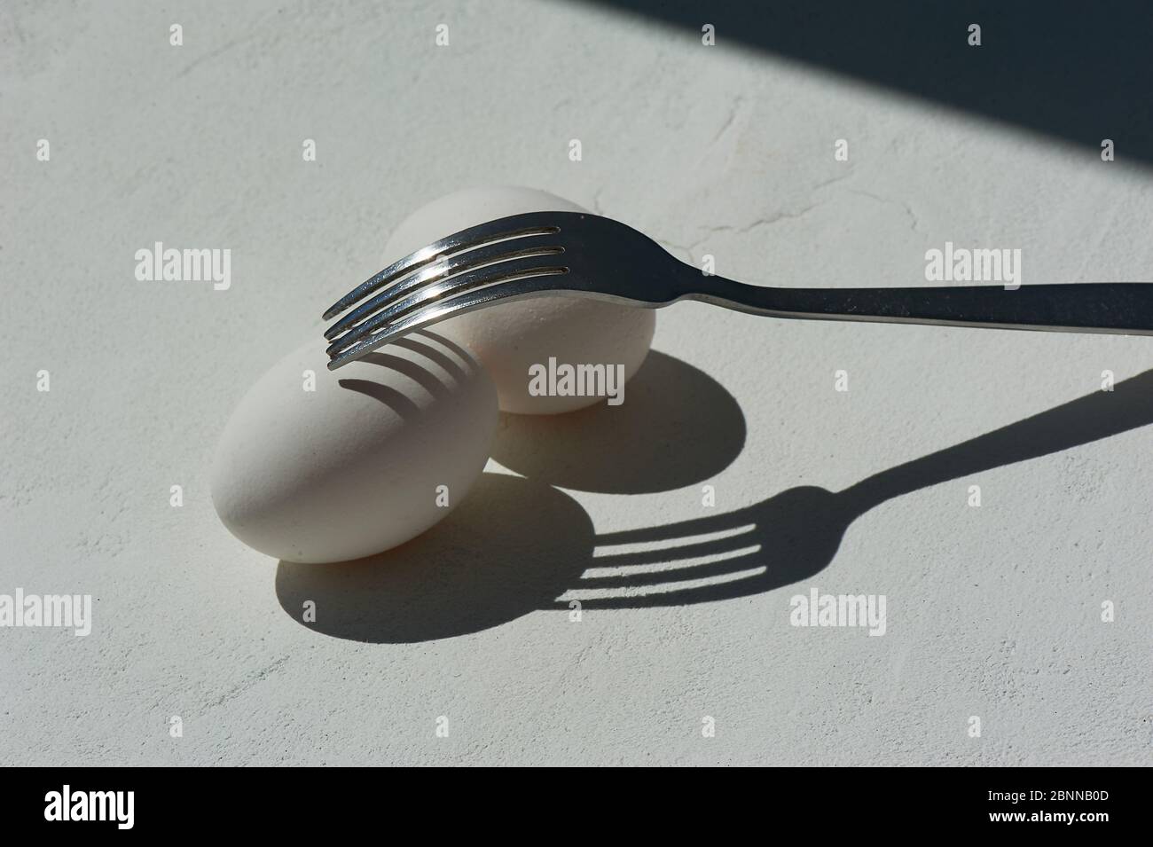 Egg with shadow from the fork.Minimalism. Cooking pastries, omelets ...
