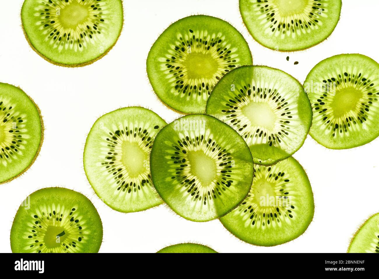 Backlit kiwi fruit slices on white background. Top view layout Stock ...