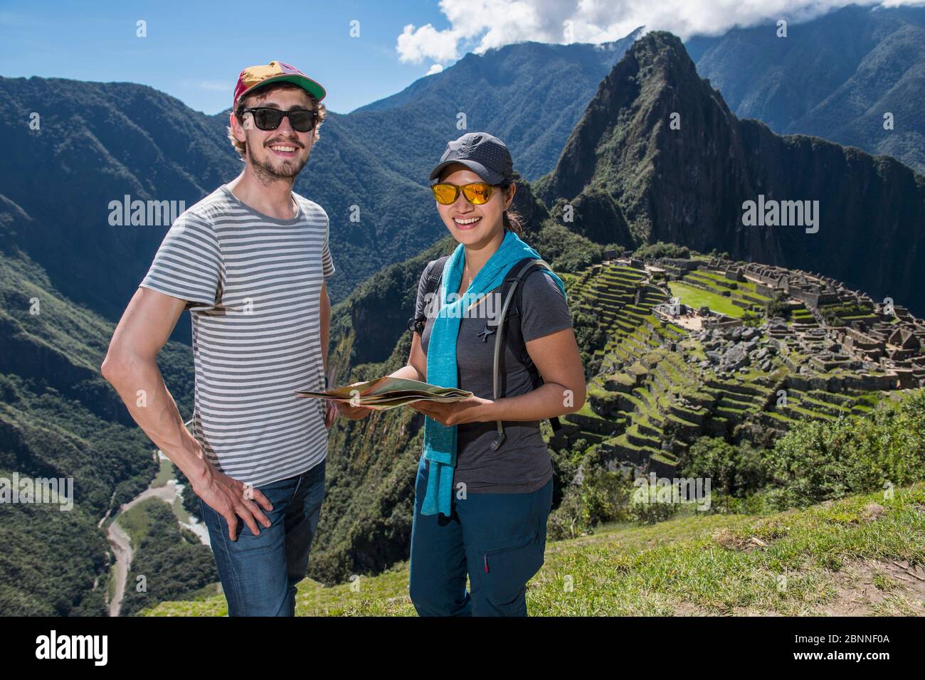 Couple at Inca ruins looking at camera smiling, Machu Picchu, Peru ...