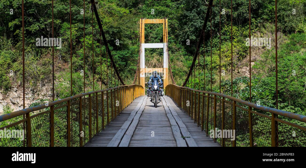 Man driving touring motorbike on suspension bridge in Peru Stock Photo ...