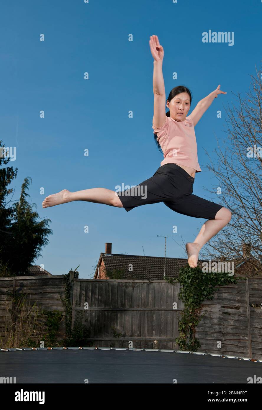 mature woman jumping on trampoline in Woking - England Stock Photo - Alamy