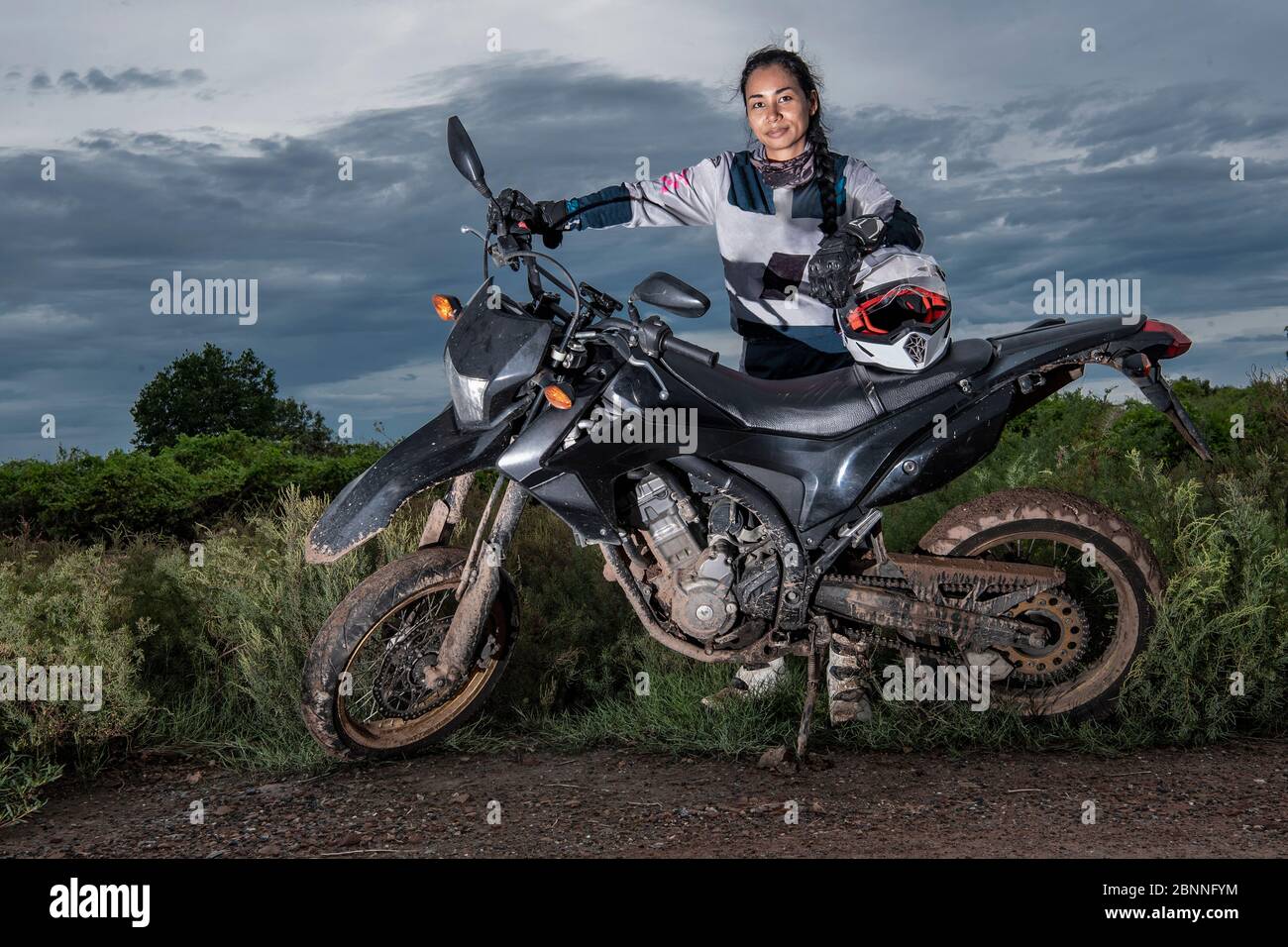 Woman posing behind her super moto style motorcycle on dirt road Stock ...