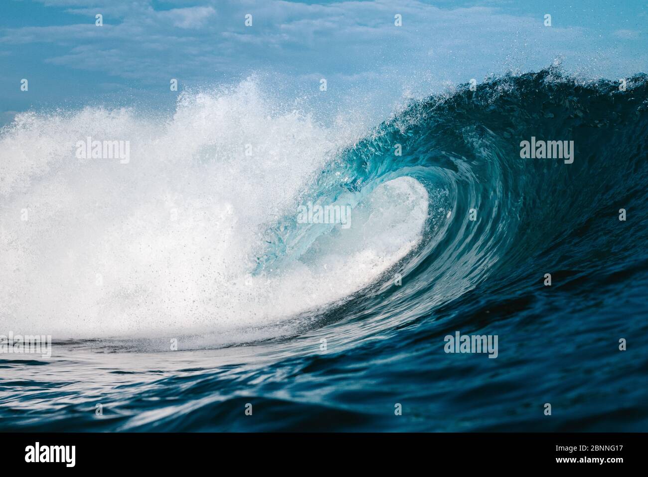 Blue wave breaking on a beach in Indonesia Stock Photo - Alamy