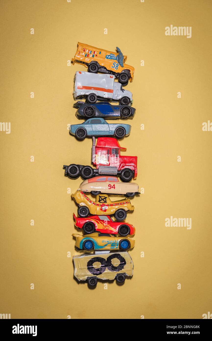 Toy cars stacked on top of each other on yellow background Stock Photo ...
