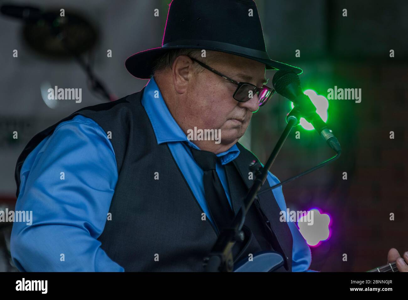 Senior male singer and lead guitar player, in outdoor concert, wearing ...