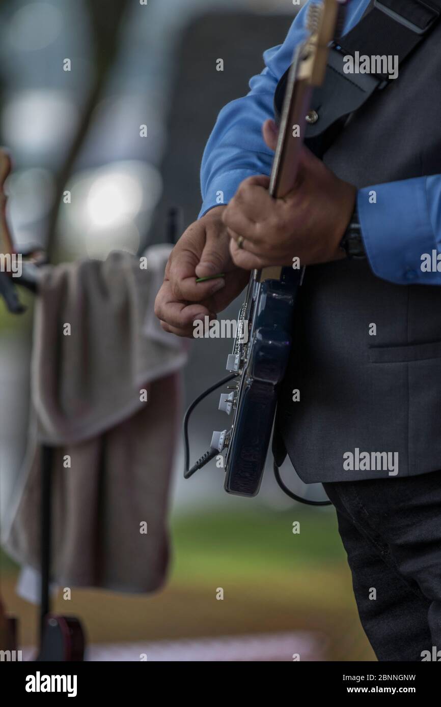 Senior male singer and lead guitar player, in outdoor concert, wearing ...