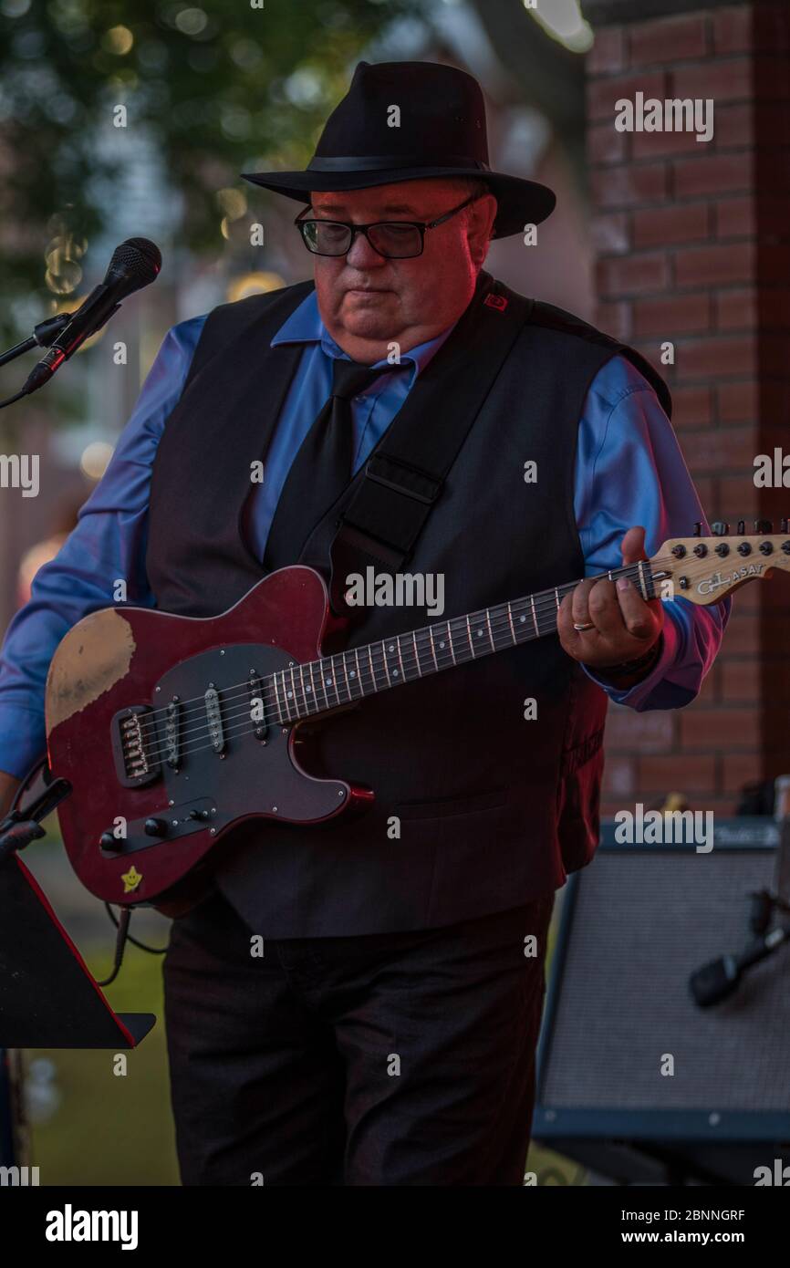 Senior male singer and lead guitar player, in outdoor concert, wearing ...