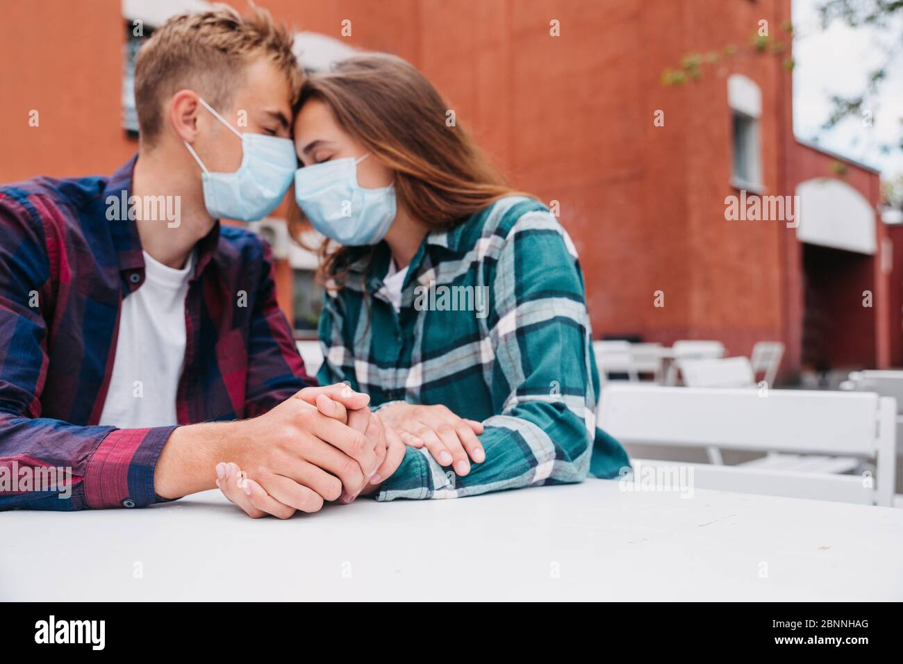Couple in love, man and woman kissing each other in protective medical ...