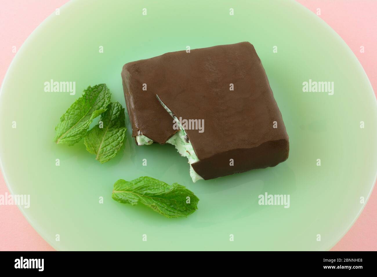 Mint chocolate chip ice cream bar covered in milk chocolate on green ...