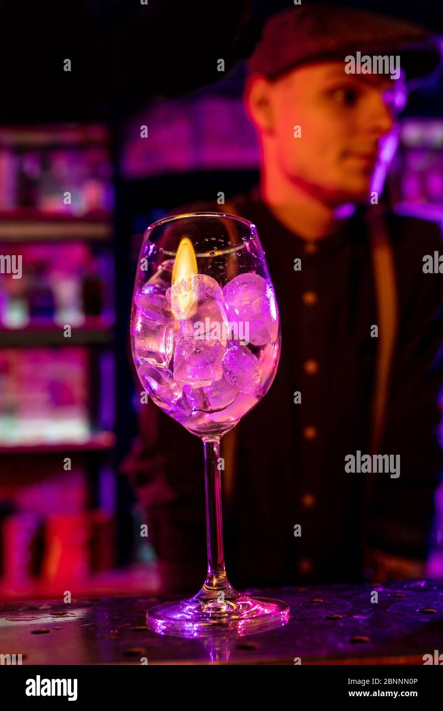 Close up of professional barman finishes preparation of alcoholic ...
