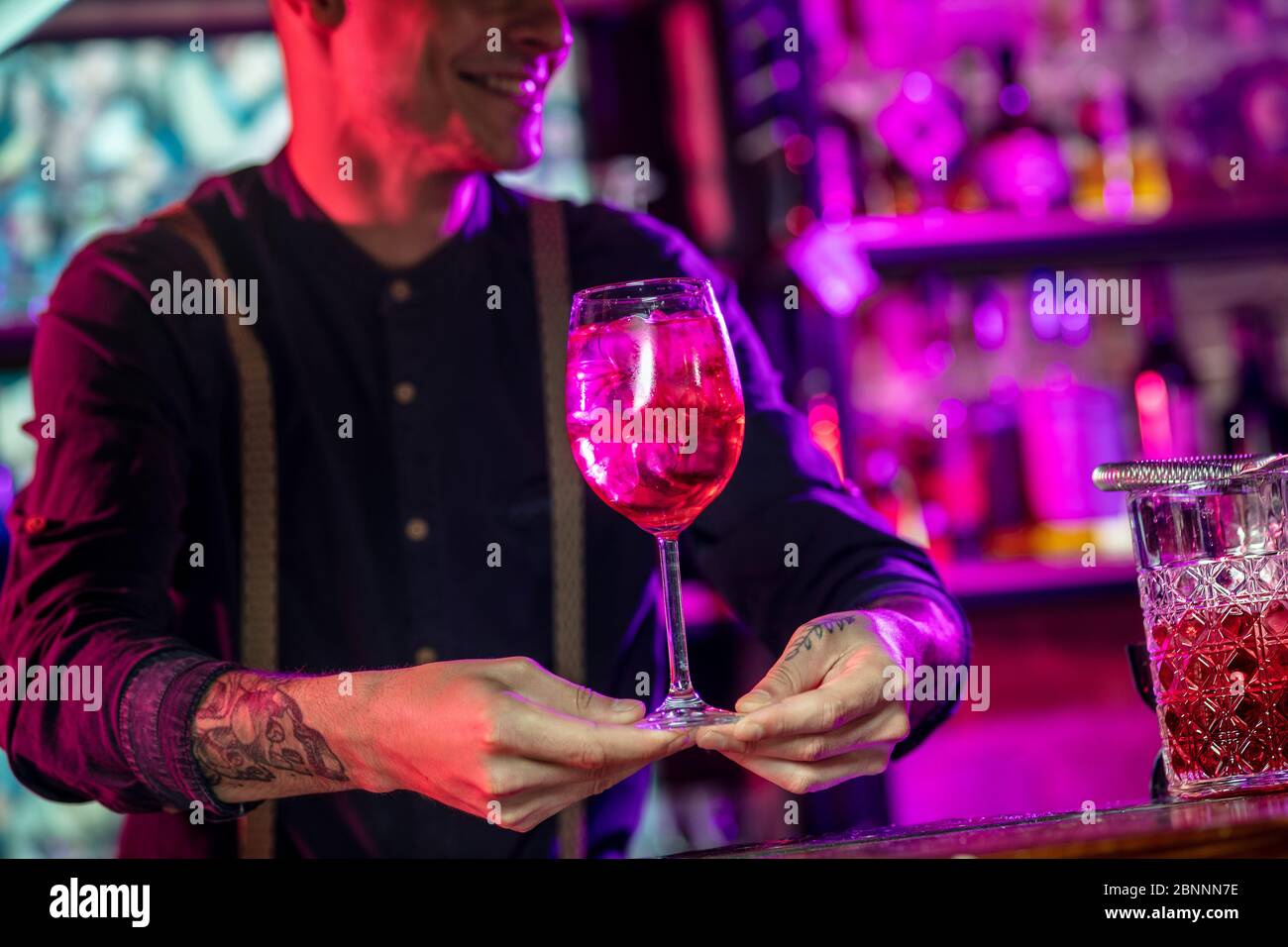 Professional barman proposing alcoholic cocktails, shots, beverages to ...