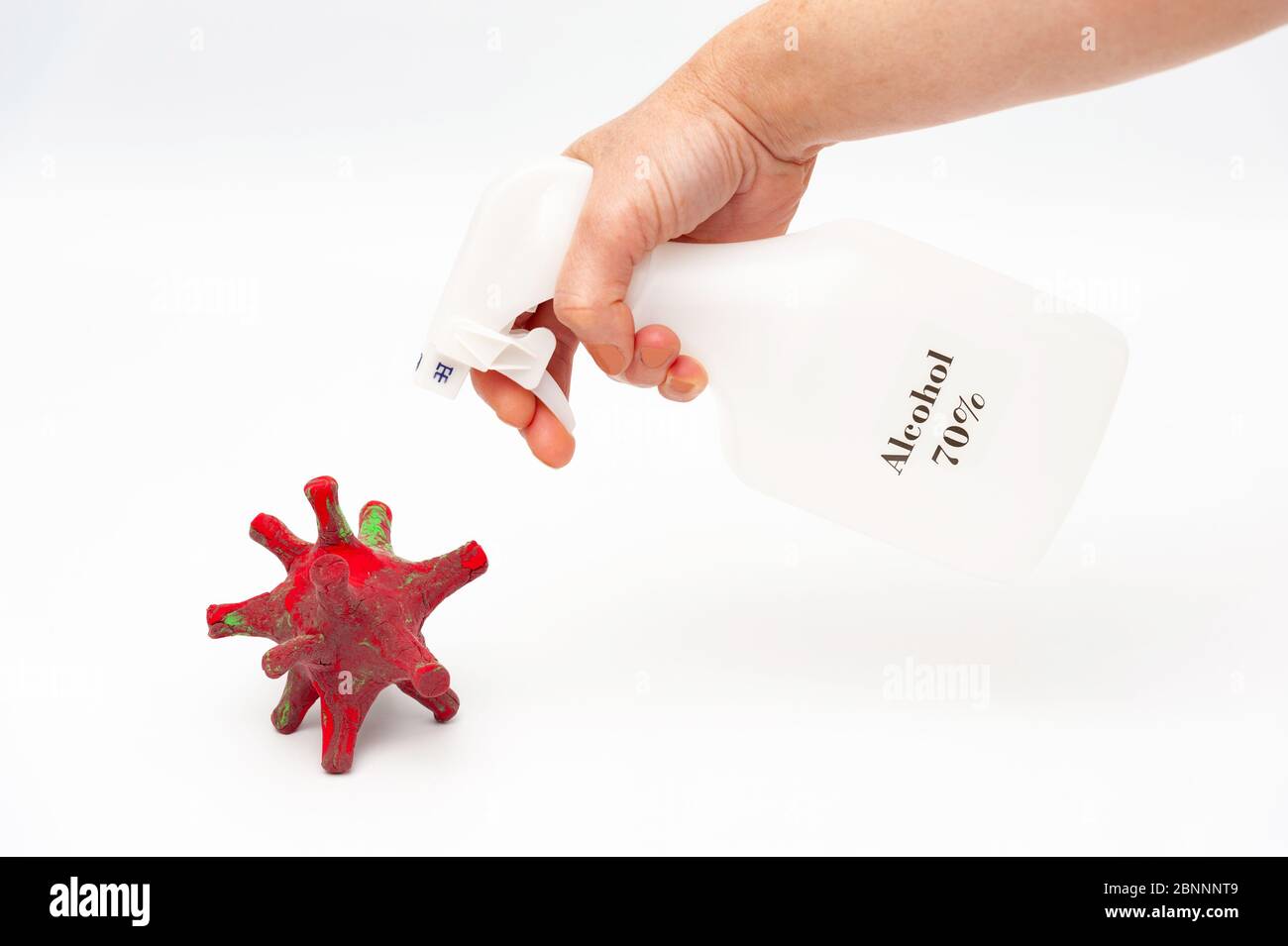 Hand spraying 70% alcohol on DIY homemade coronavirus model with ...