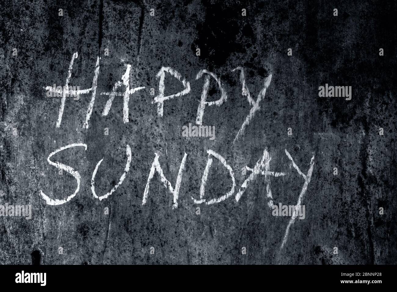 Happy Sunday wrote on the rough wall with yellow-colored chalk, close ...