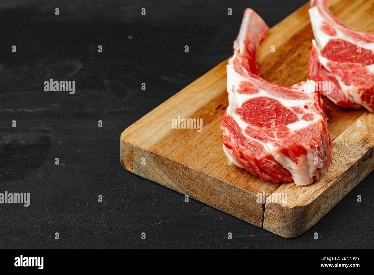Racks of lamb ready for cooking on dark background Stock Photo - Alamy