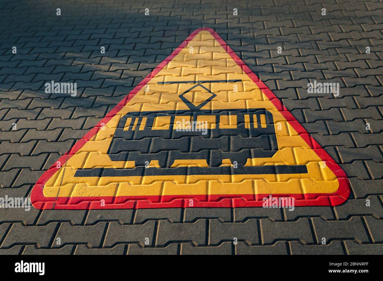Yellow red triangular tram sign drawn on the road Stock Photo - Alamy