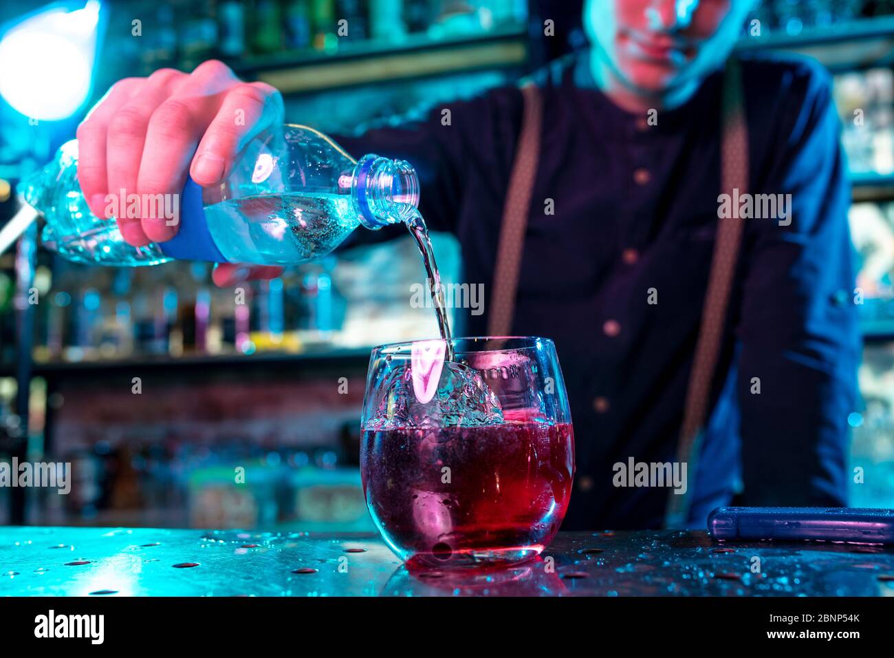 Close up of professional barman finishes preparation of alcoholic ...