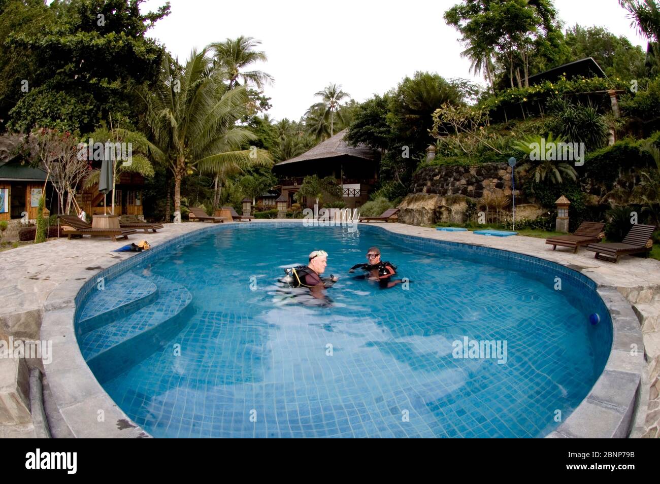 Elderly male tourist learning to dive in pool with instructor, Lembeh ...