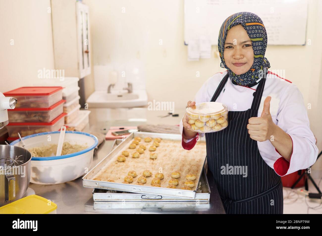 happy muslim business woman. bakery owner with product on container ...