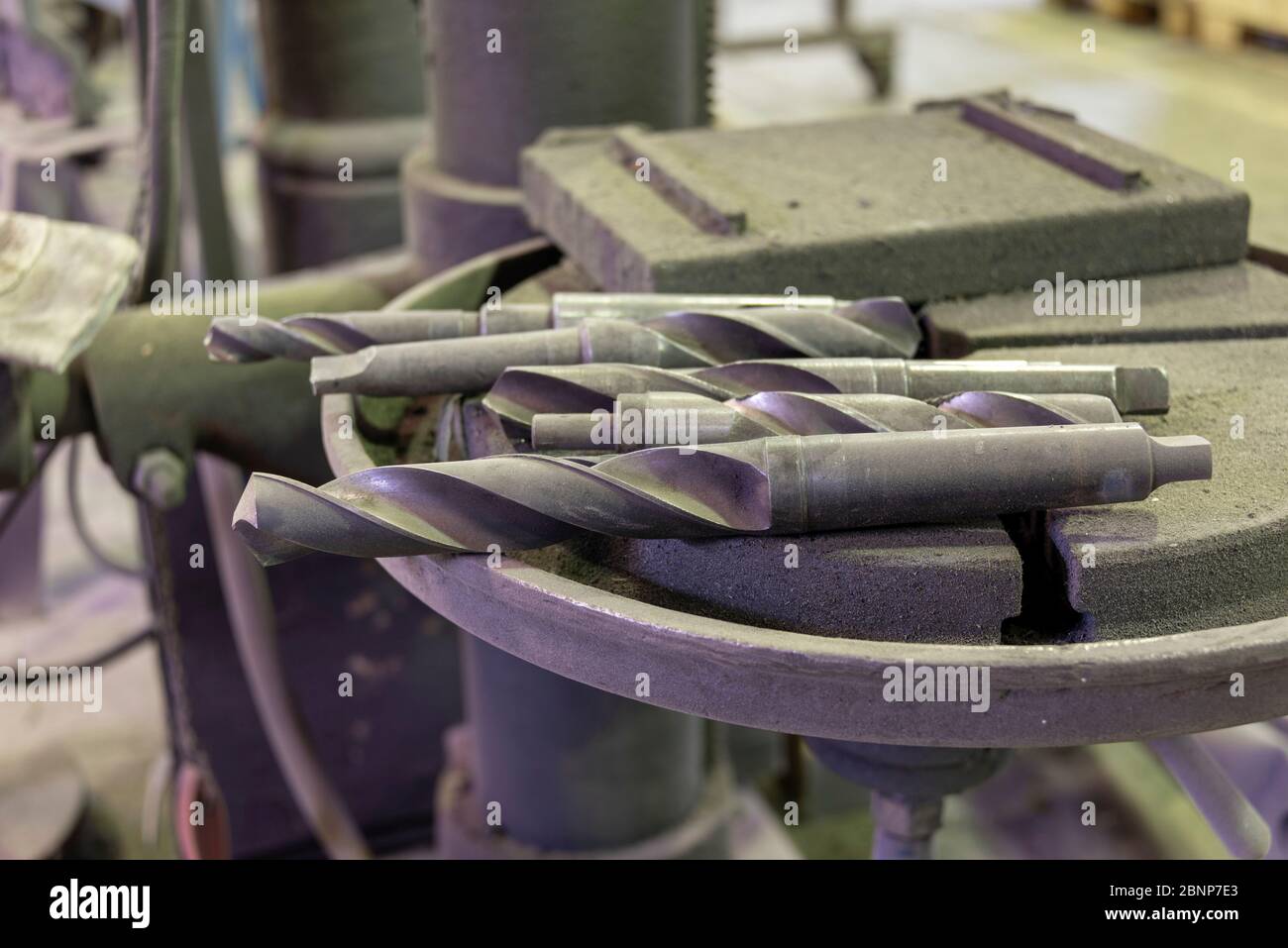 Drilling lies on a drilling table in a workshop Stock Photo - Alamy