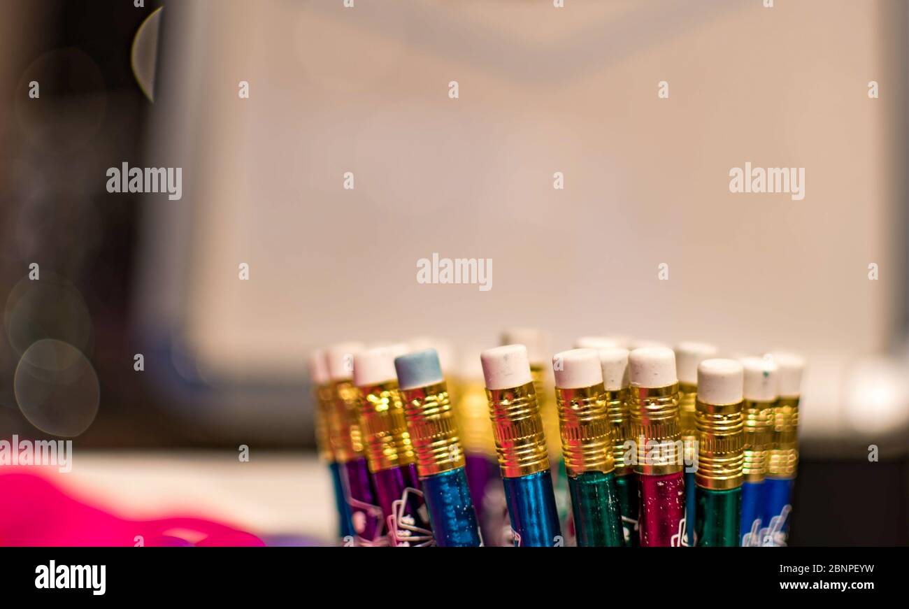 Pencils inside a cup showing it's eraser Stock Photo - Alamy