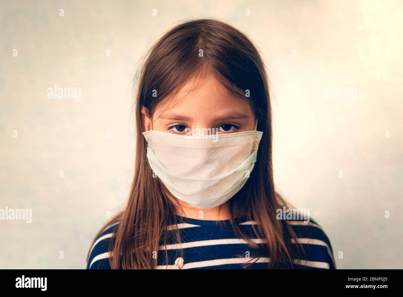 A young pretty girl put on a medical mask. Portrait of a child in a ...