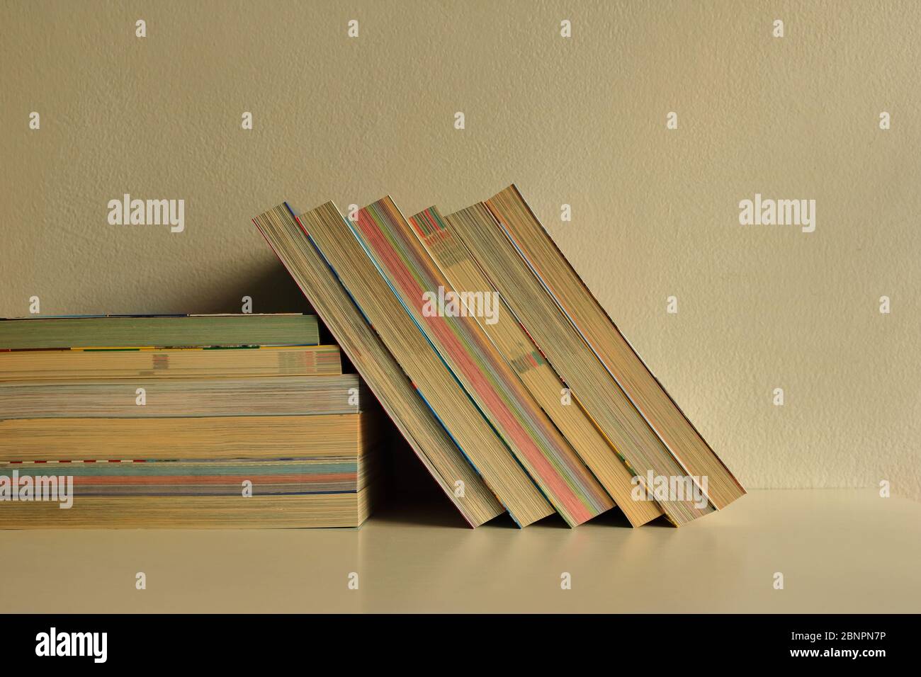 Selective focus on row of books in vertical position leaning against ...