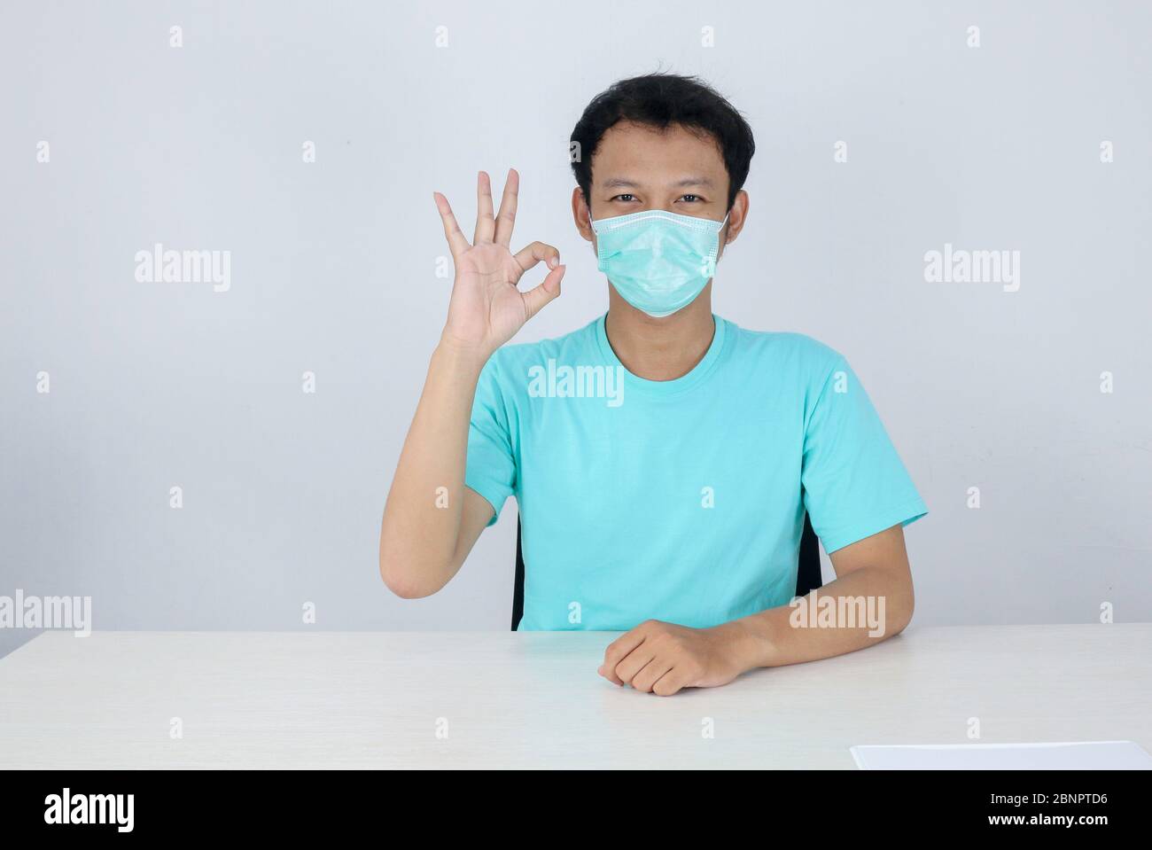 Young Asian Man wear medical mask is give ok hand sign with confident ...