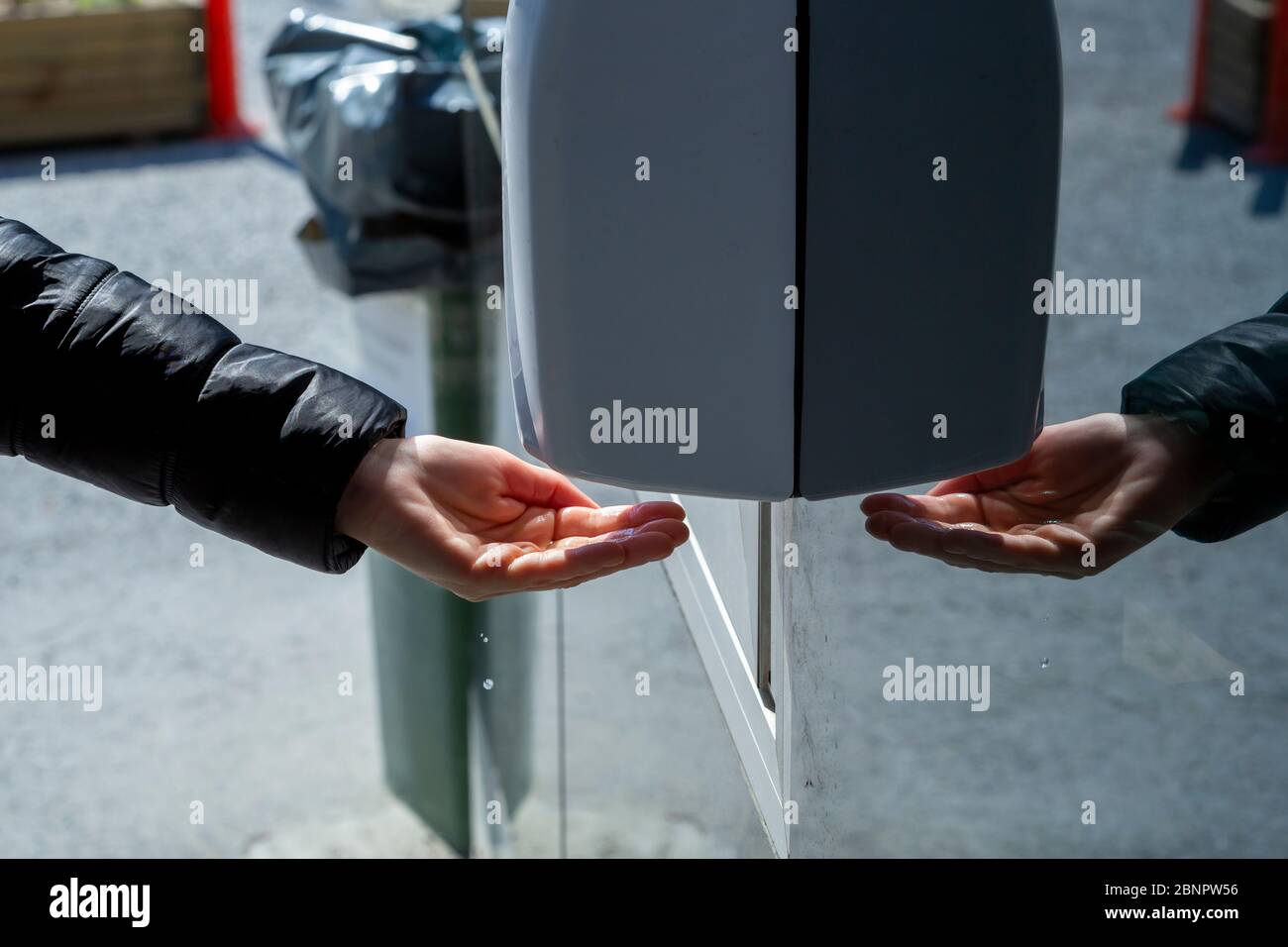Hand using alcohol gel disinfecting hands Stock Photo - Alamy